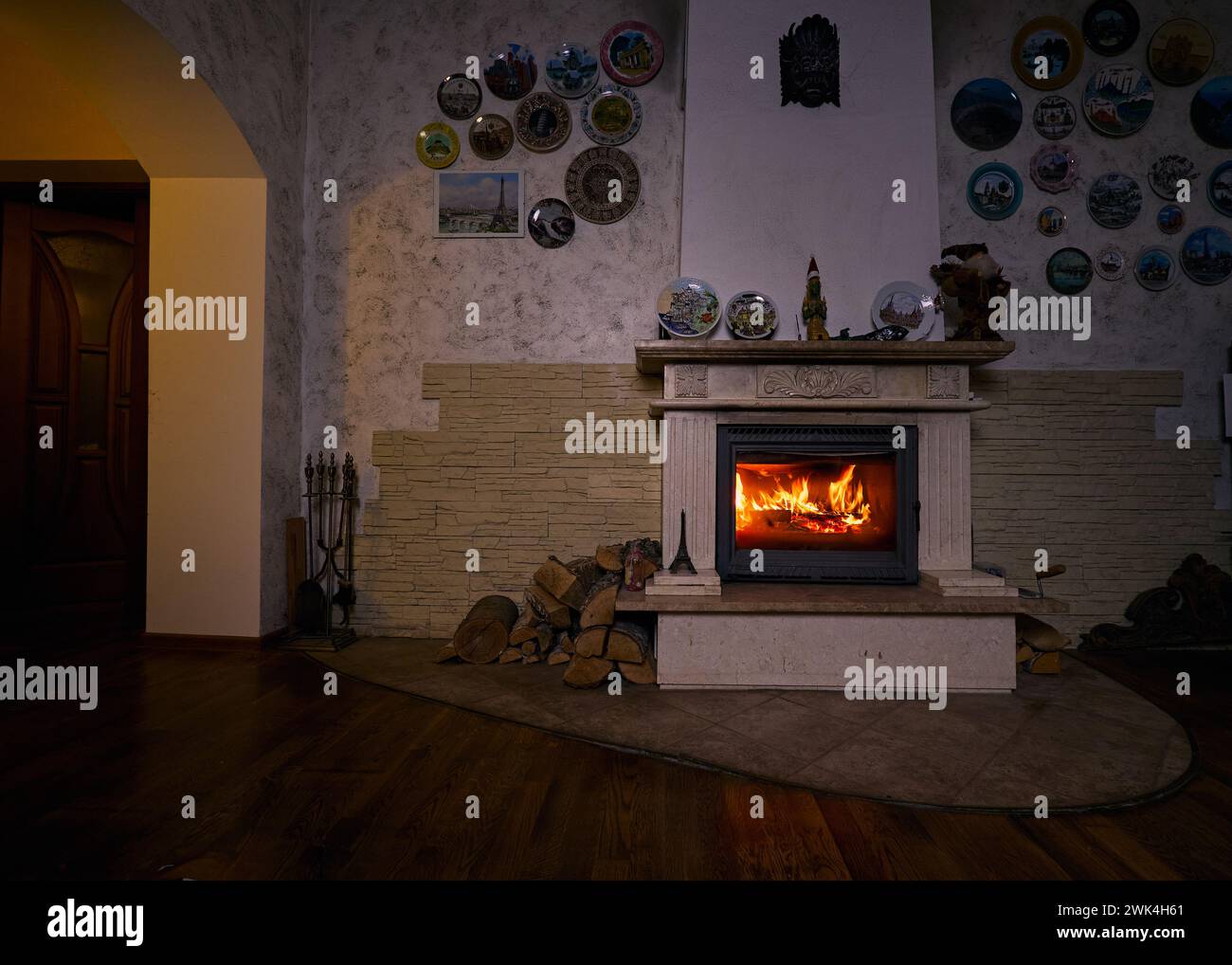 Closed fireplace with wood burning in the firebox, ceramic plates on ...