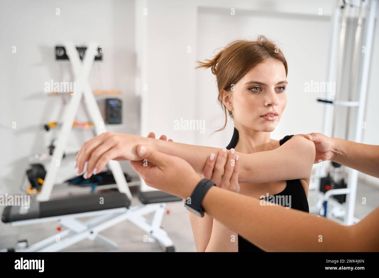 Physiotherapist helping patient perform stretching exercises for arm ...