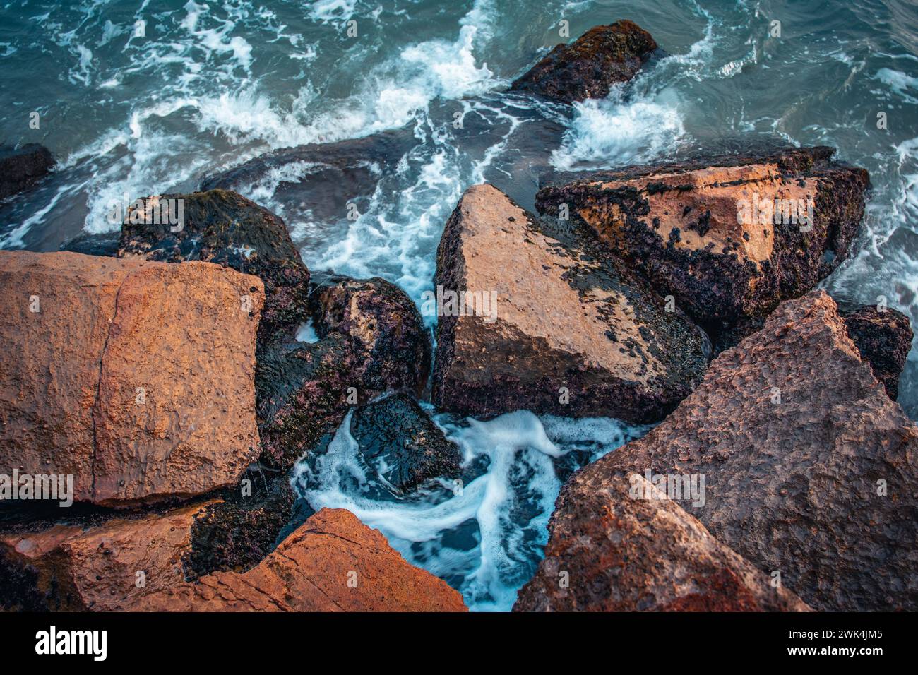 Mediterranean winter stormy seaside. Close up water with stones on the ...