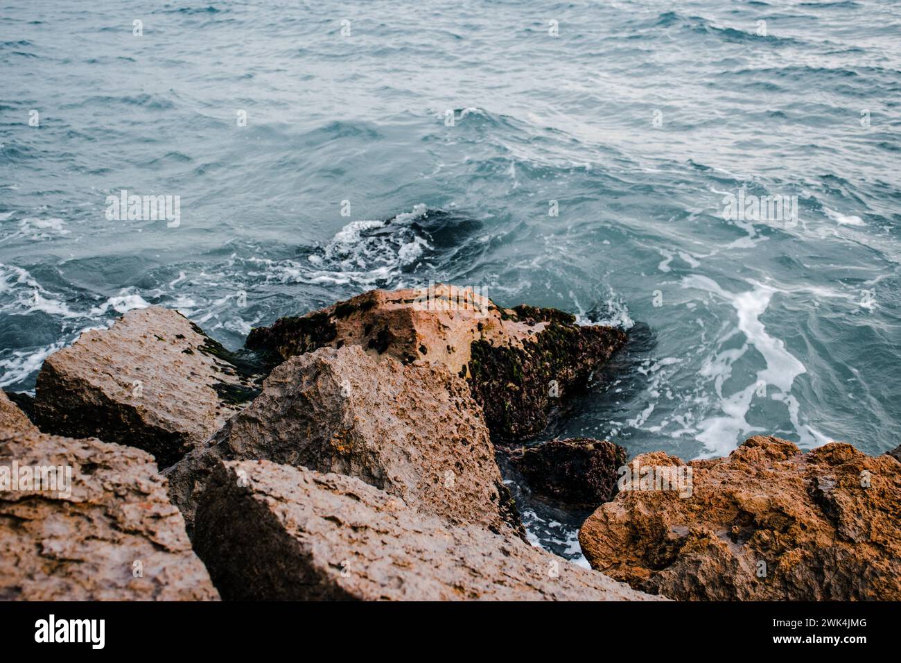 Mediterranean winter stormy seaside. Close up water with stones on the ...