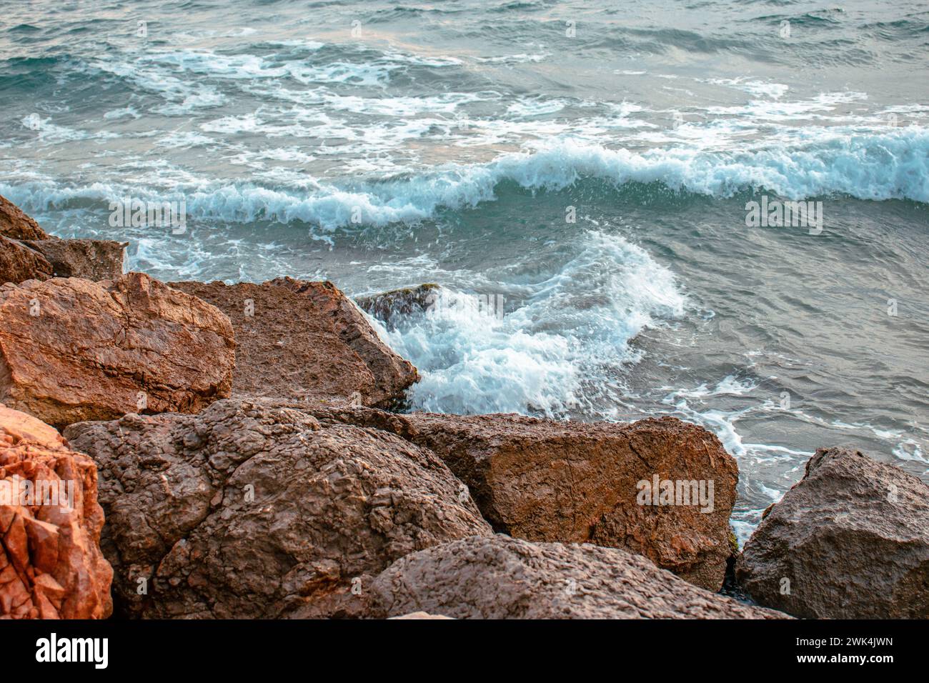 Mediterranean winter stormy seaside. Close up water with stones on the ...