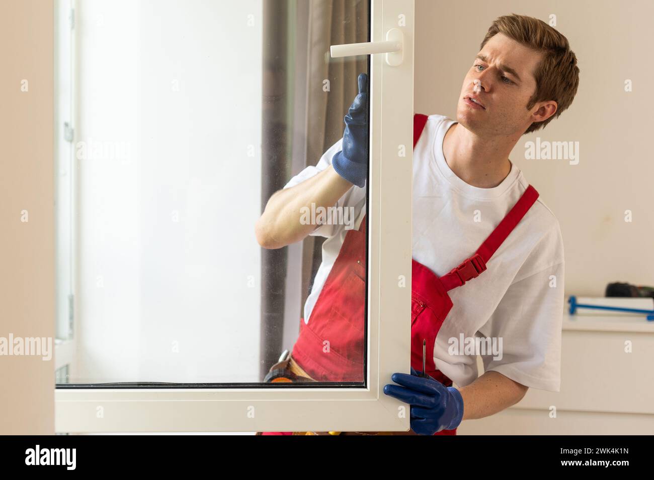 Construction worker installing window in house Stock Photo - Alamy