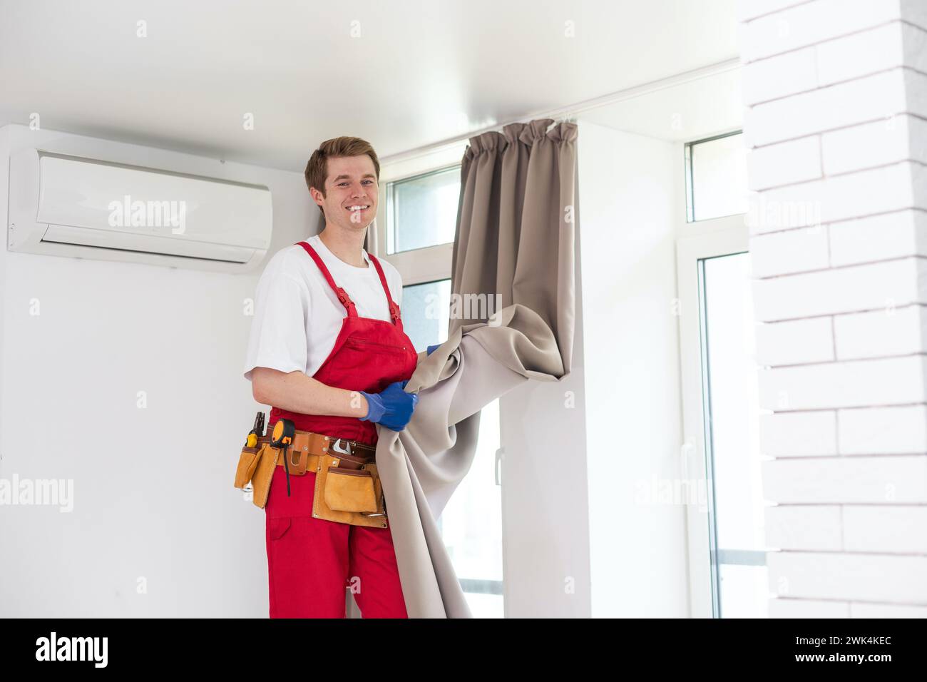 worker installing window curtain rod on the wall Stock Photo - Alamy