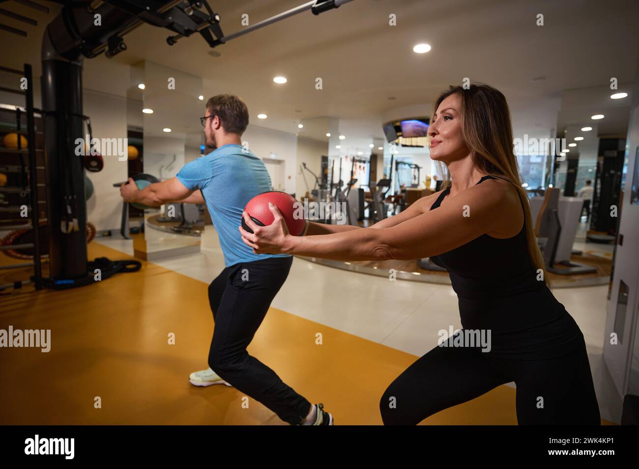 Female and male perform exercises with a ball Stock Photo - Alamy