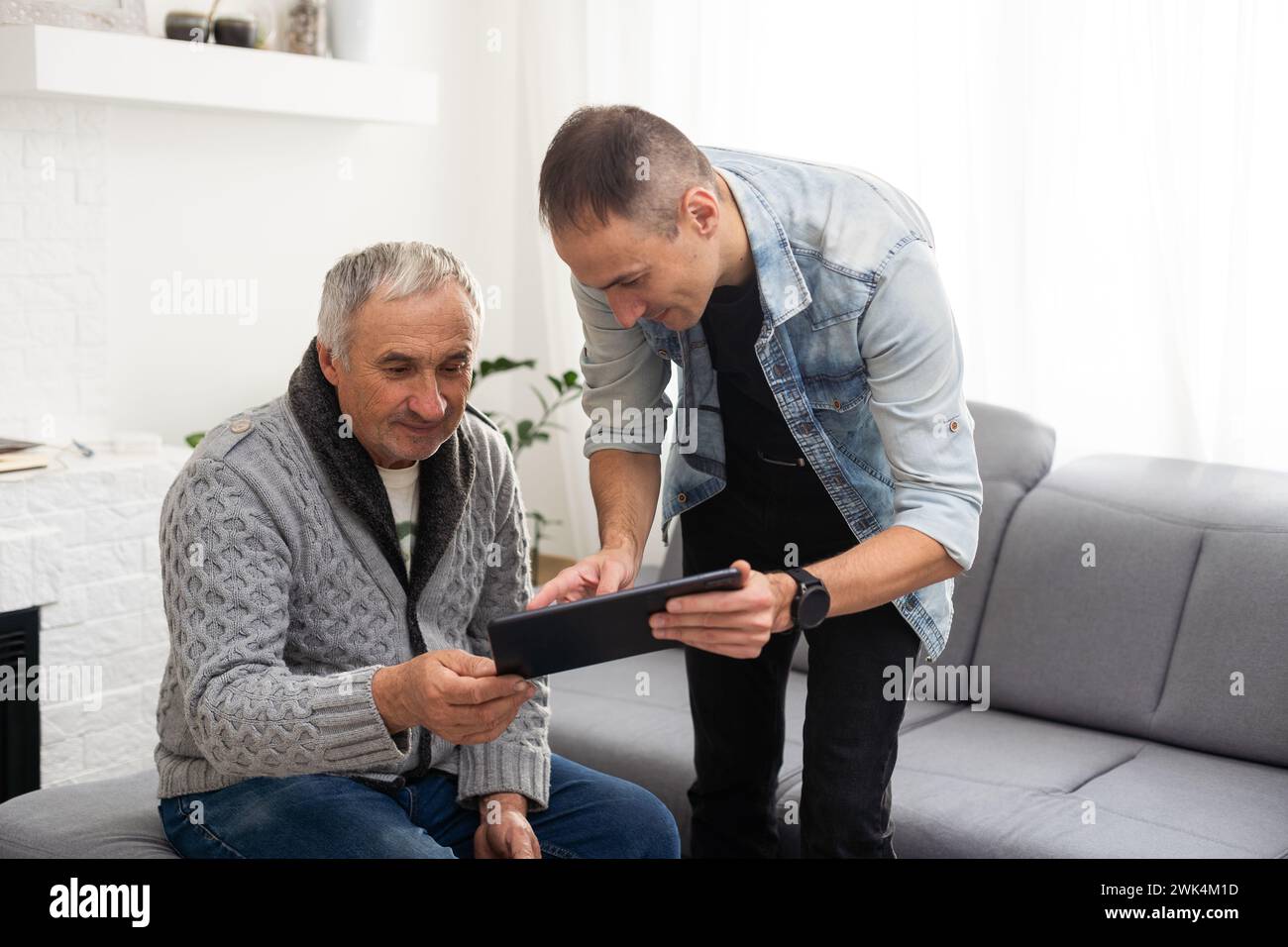 Elderly son takes care of ill father Stock Photo - Alamy