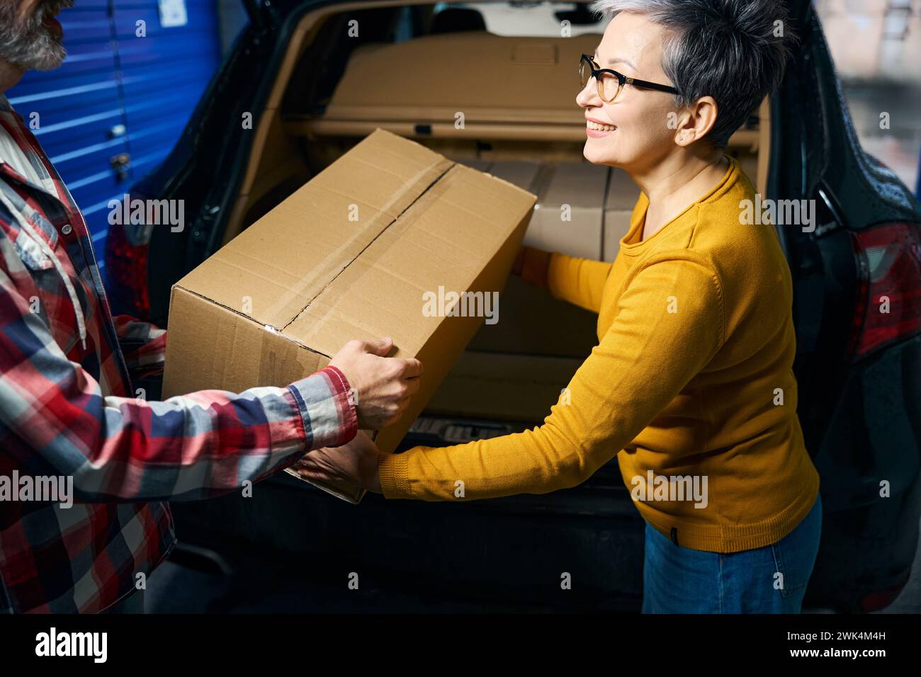 Adult woman giving a box of things to a man Stock Photo - Alamy