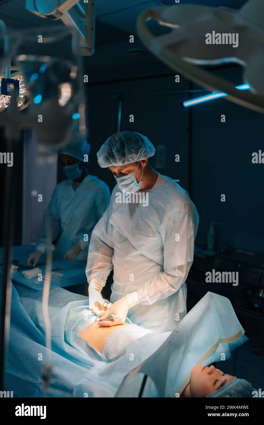Vertical portrait of surgery professional operating female patient ...