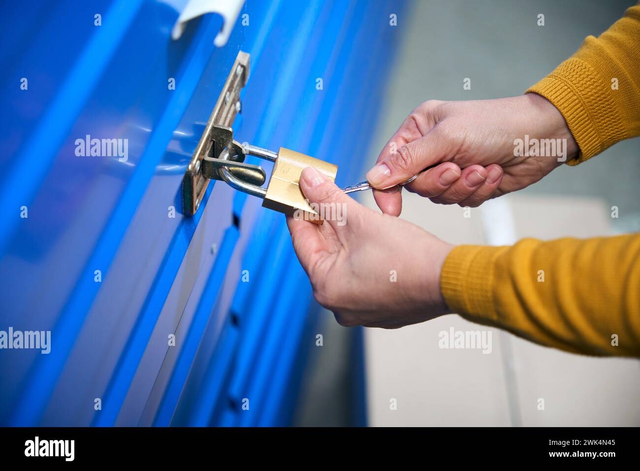 Lady in a sweater opens a padlock with her keys Stock Photo - Alamy