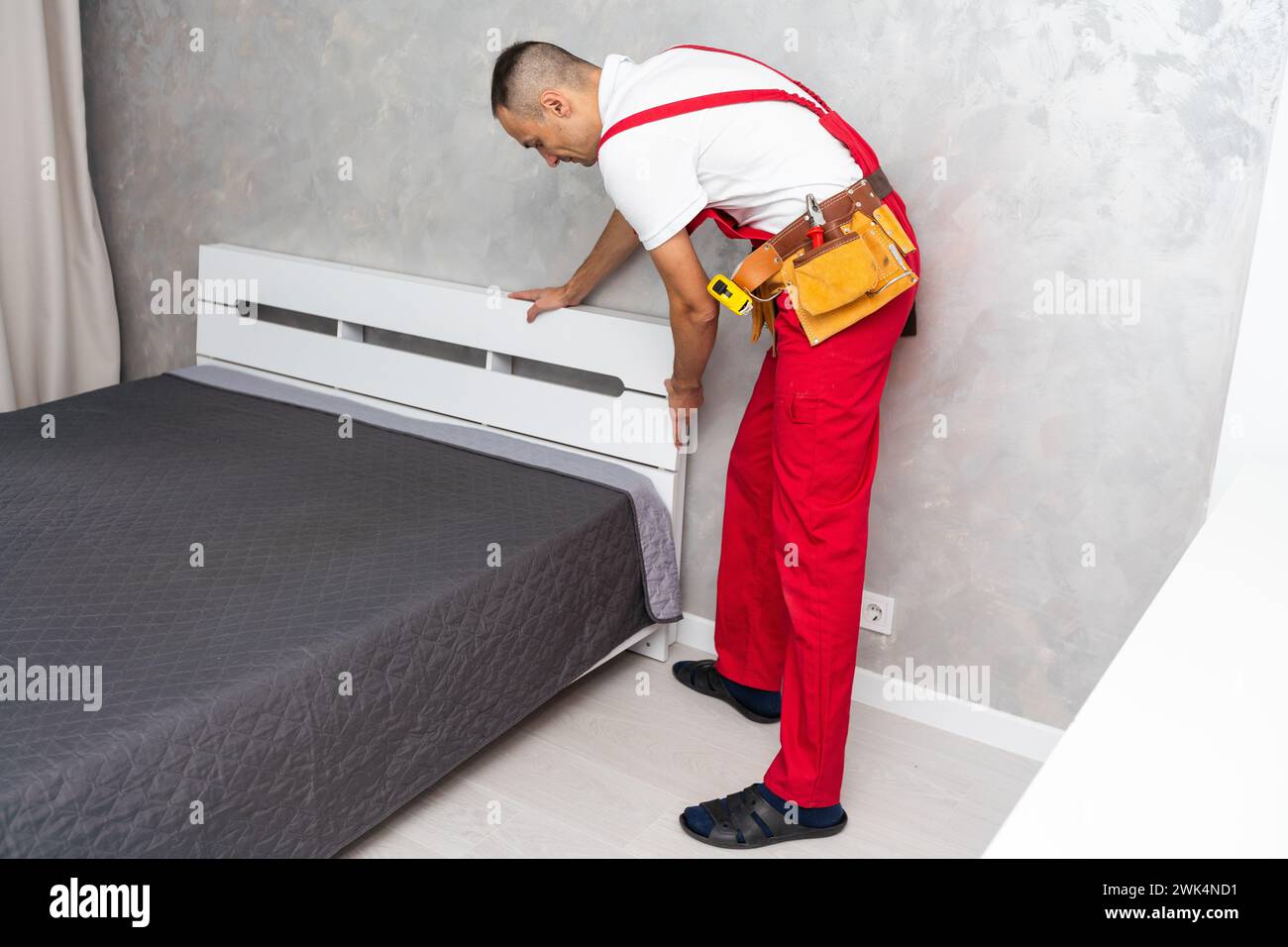 Man furniture maker assembles bed. Process production interior items ...