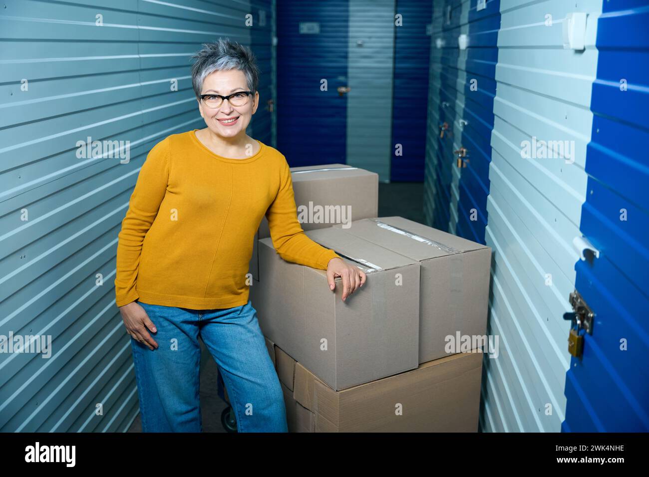 Adult lady stands next to her things in cardboard boxes Stock Photo - Alamy