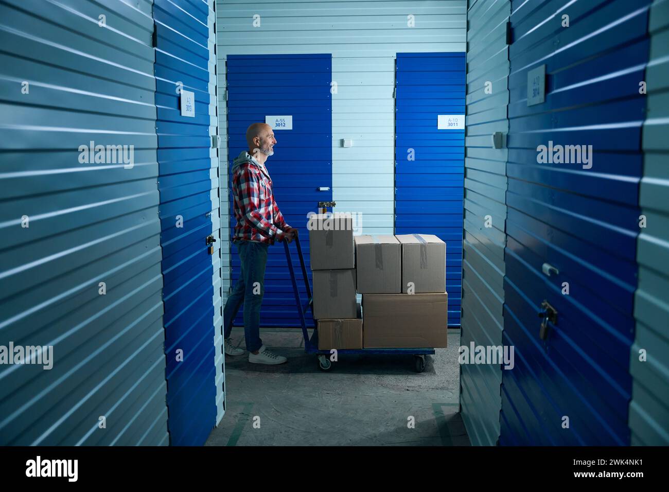 Guy is carrying a cargo cart with boxes on it Stock Photo - Alamy