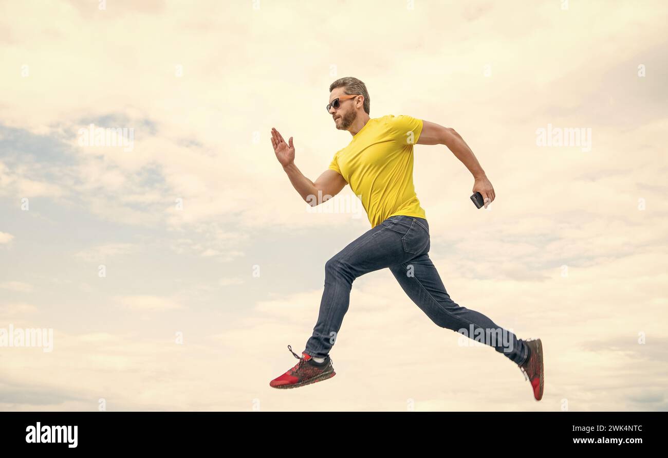 man running with smartphone on sky background Stock Photo - Alamy