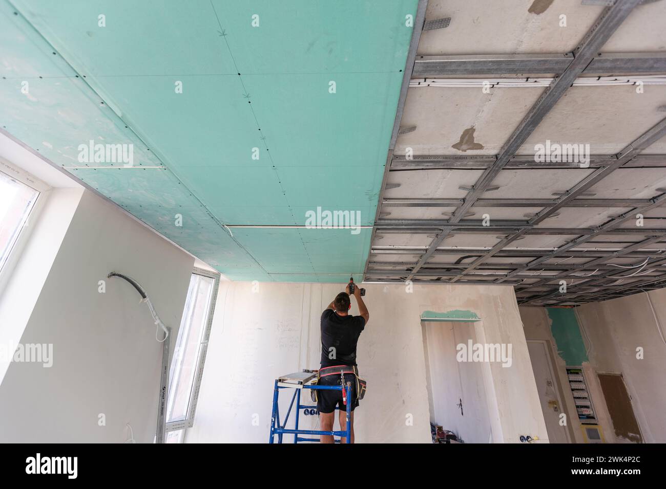 Construction worker installation ceiling work Stock Photo - Alamy