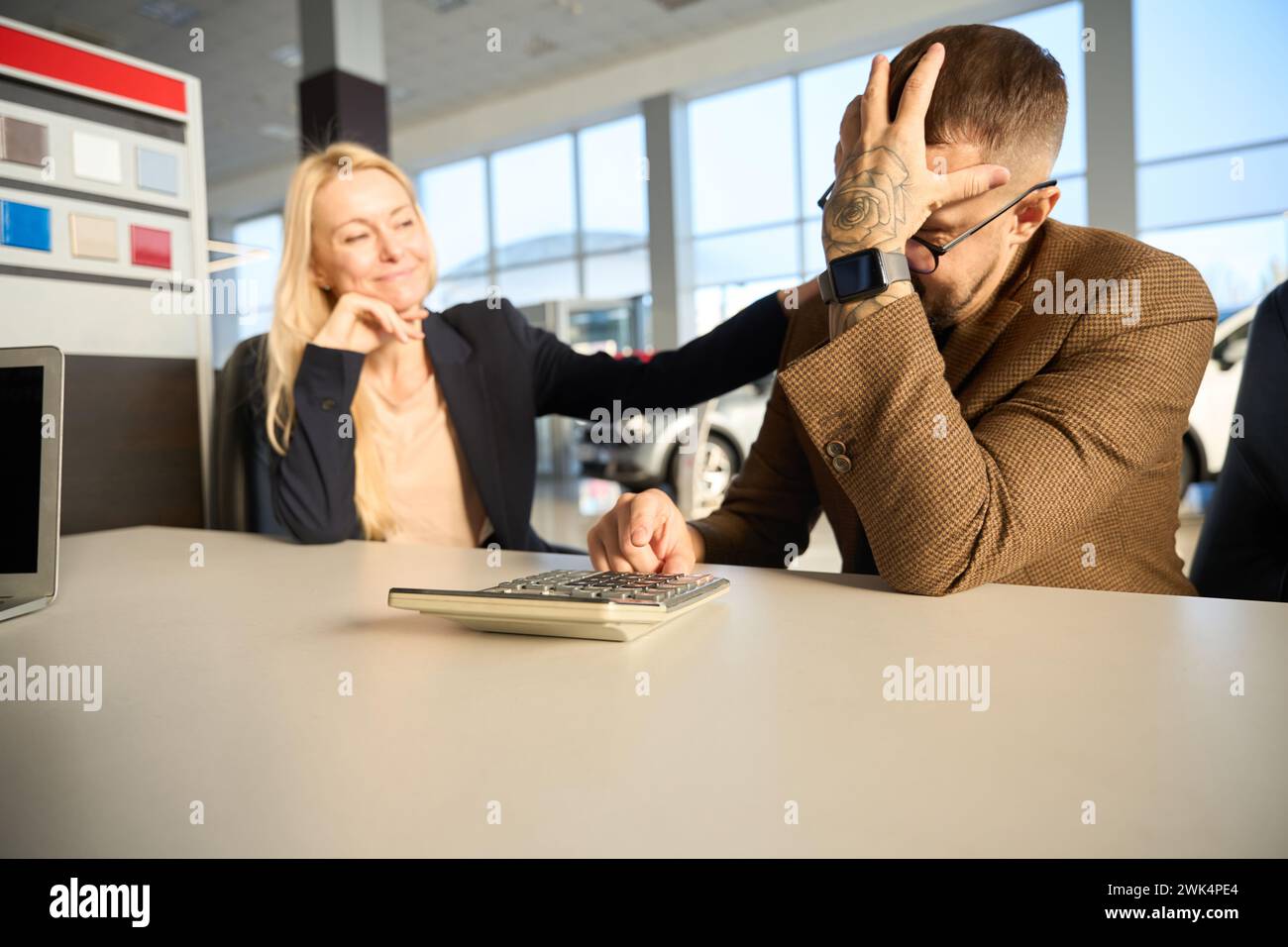 Guy holding his head in front of woman Stock Photo - Alamy
