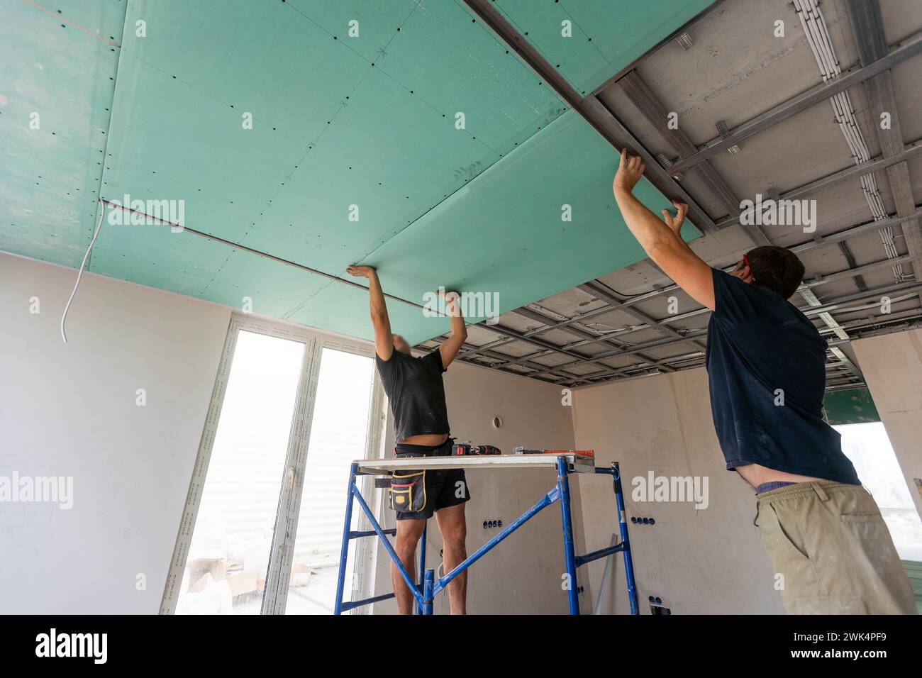 Construction worker ceiling work installation Stock Photo - Alamy