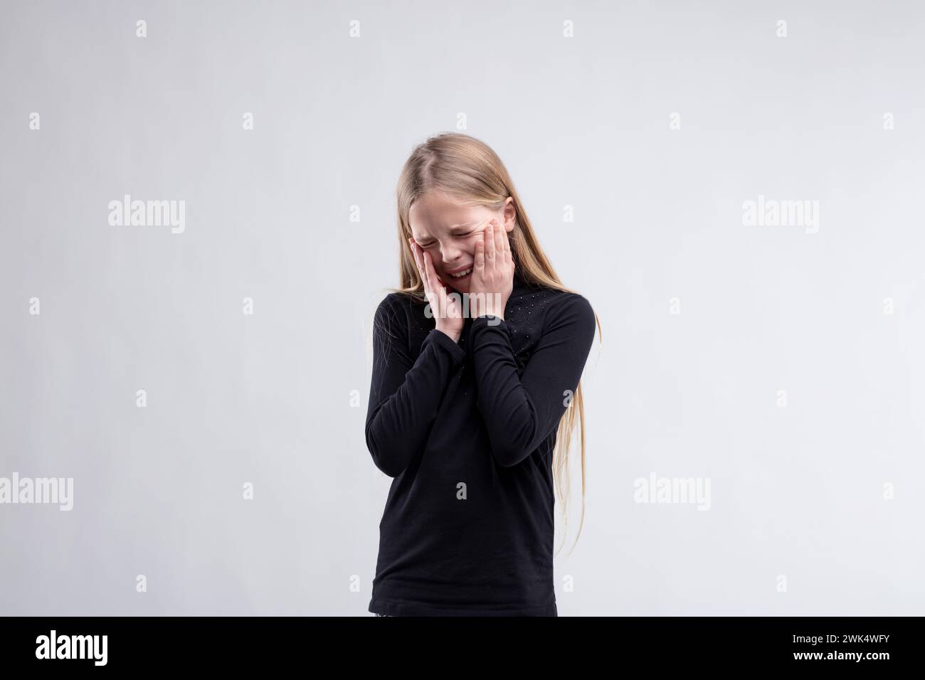 Tears brimming, hands to face, she embodies the crushing weight of fear ...