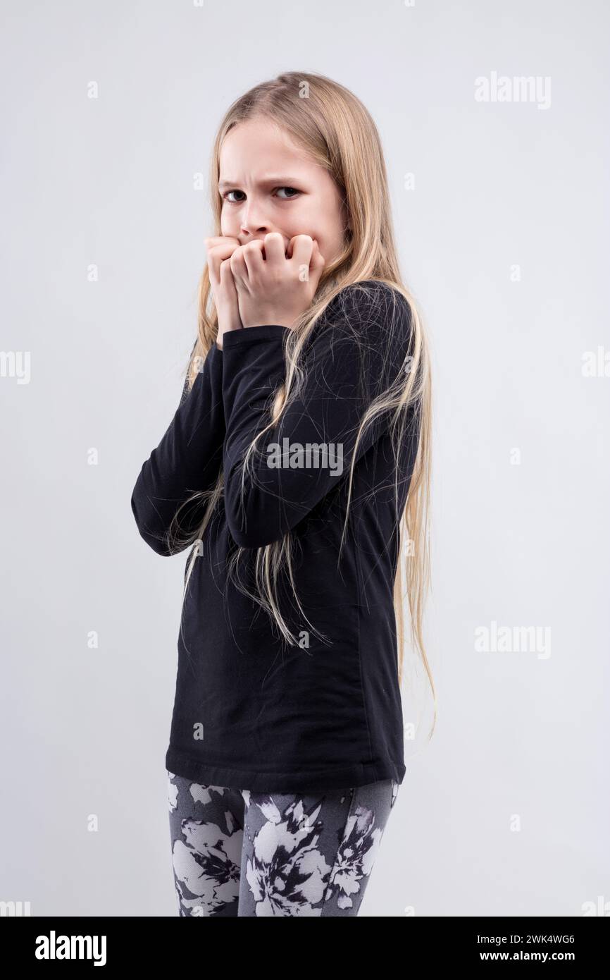 child's fearful gaze and protective stance suggest she's facing ...