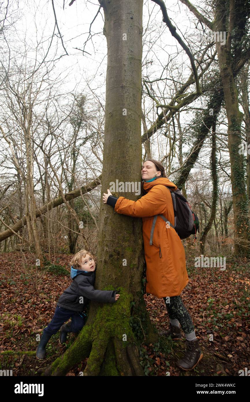 Mother and son hugging a tree happy seeking connection with nature ...