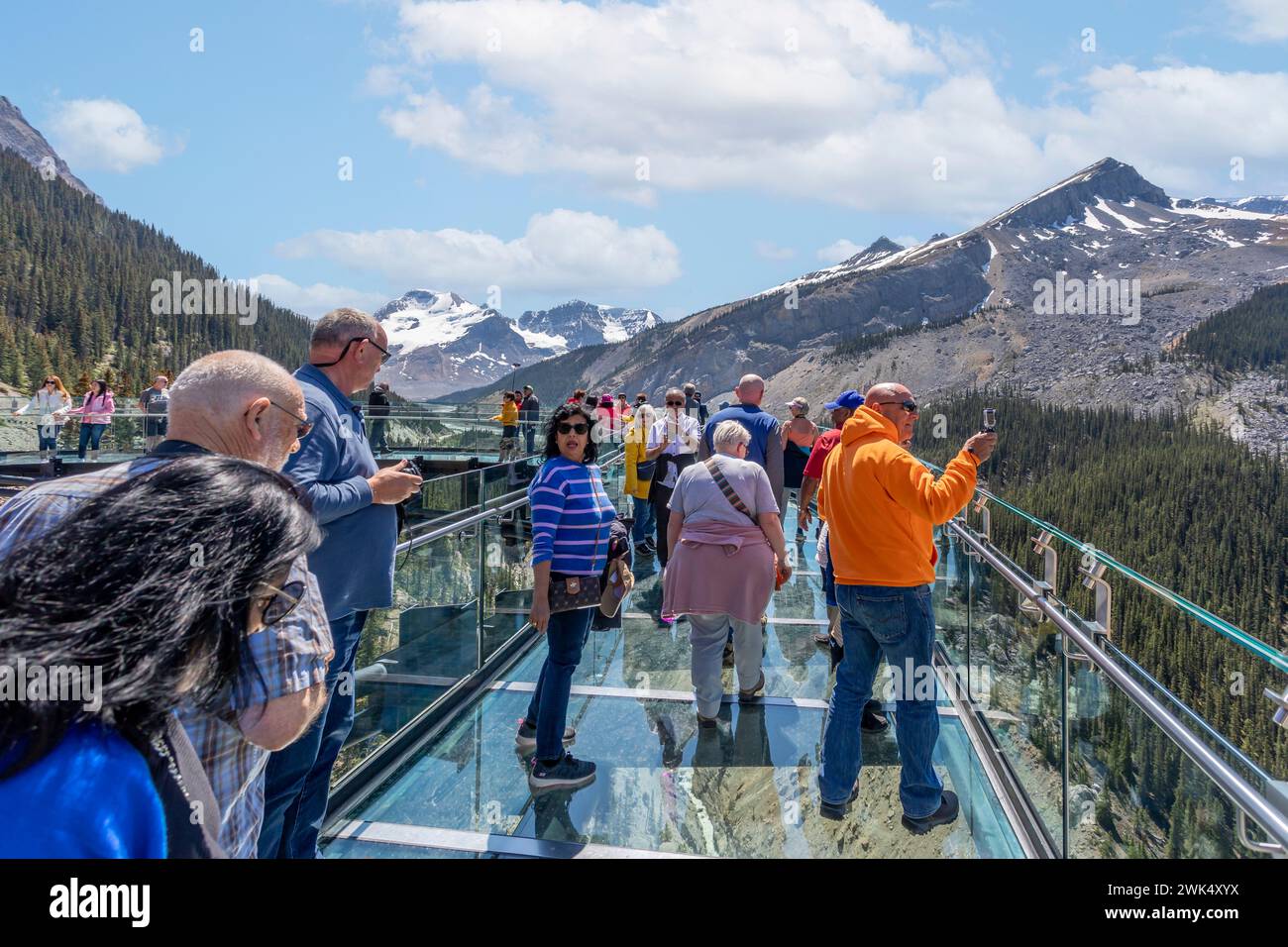 Tourists standing on the glass floored observation deck of the Columbia ...