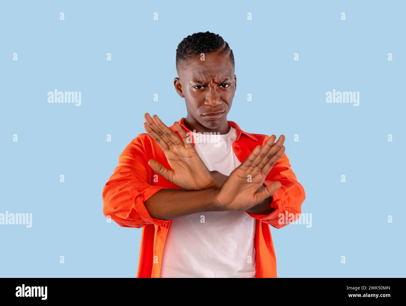 woman in orange shirt crossing hands and palms in refusal negative ...