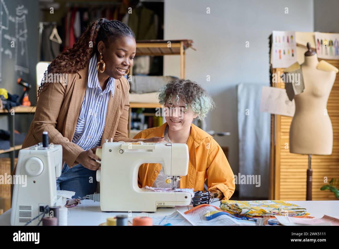 Portrait of smiling teen girl with disability using sewing machine in ...