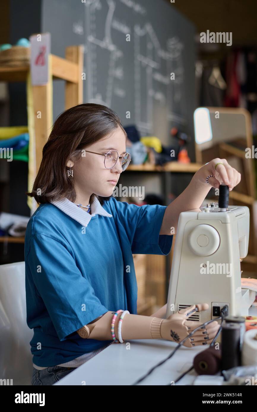 Vertical side view portrait of teenage girl with disability using ...