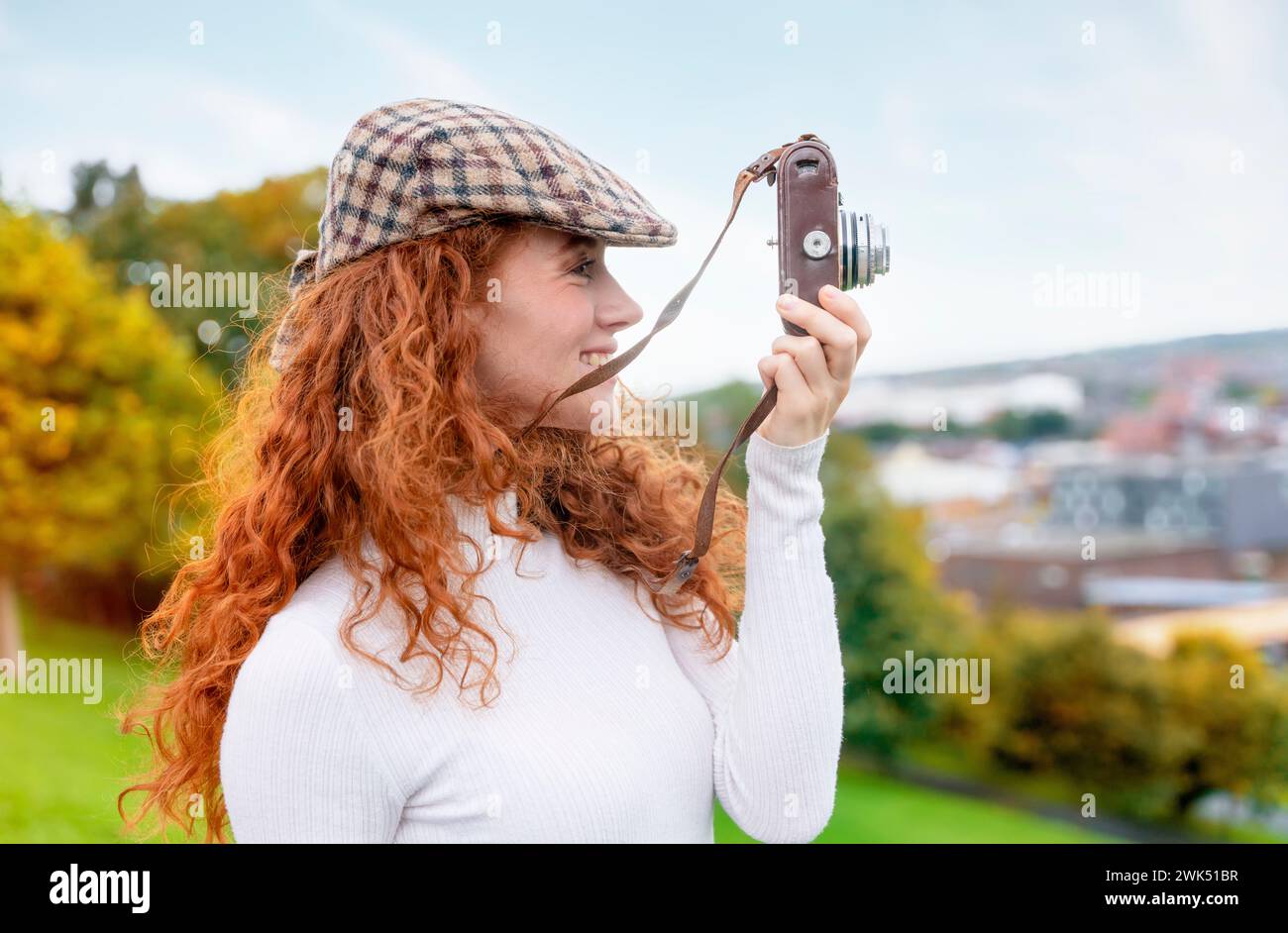 Portrait of an excited and happy young lady with red curly hair ...