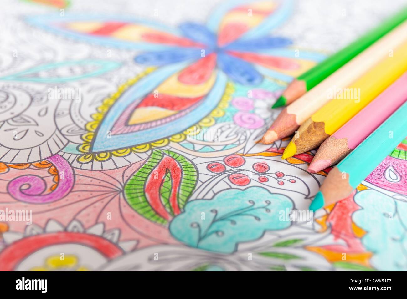 Colored mandala coloring book with pencils implies mindfulness. Mental ...