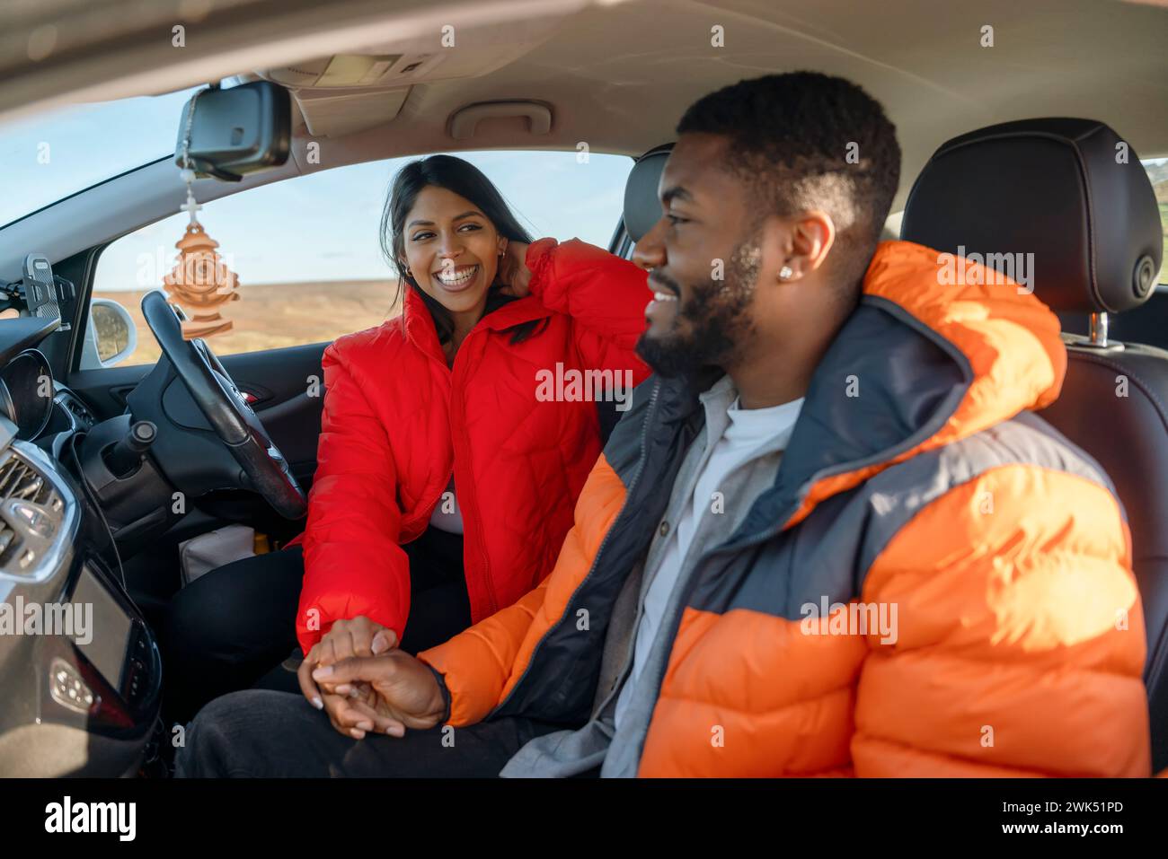 Beautiful happy young loving couple holding hands and smiling while ...
