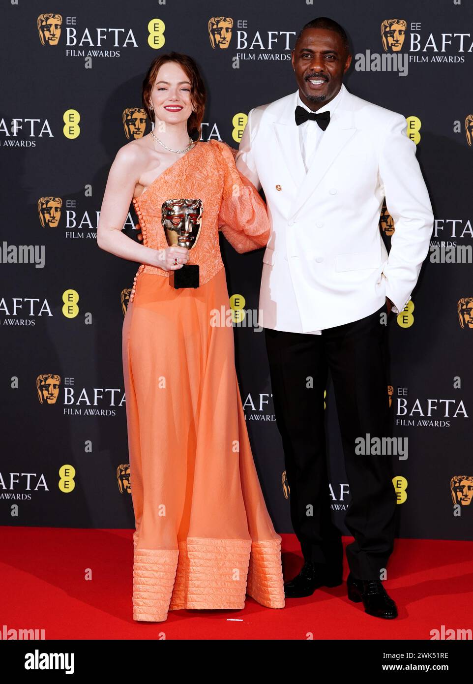 Emma Stone poses for a photo in the press room with Idris Elba after winning the Best Leading ...