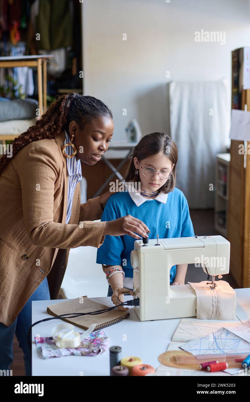 Vertical portrait of African American woman teaching girl with ...