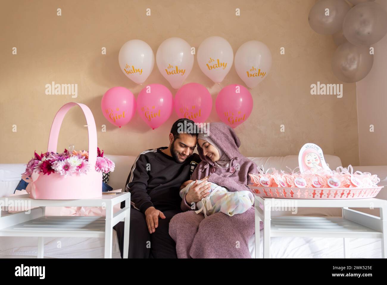 Arabic muslim couples holding their newborn baby celebration in living ...