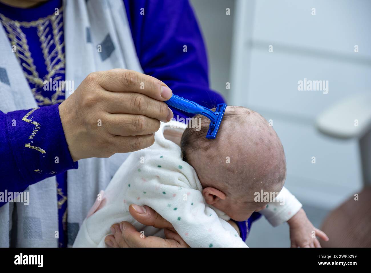 baby girl shaving her hair with sharp razor. shaving hair for 1 month ...