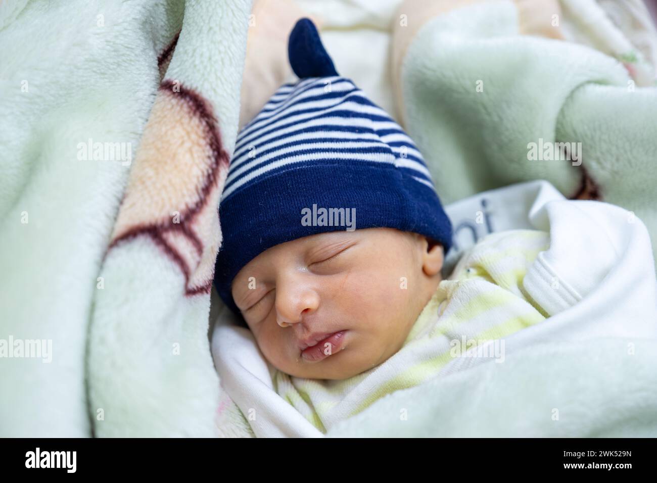 sleeping baby wearing cap with fluffy comfy bed Stock Photo - Alamy