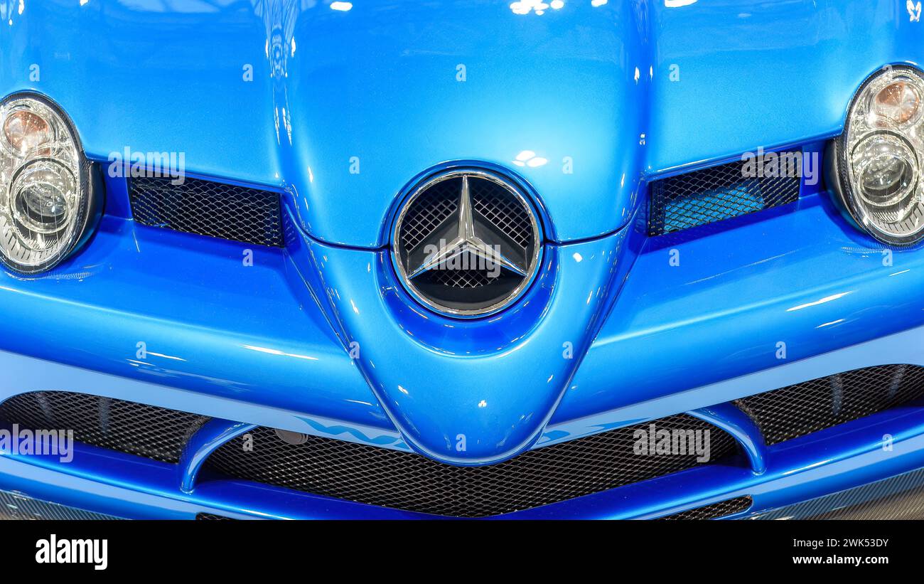 Logo, hood, and headlights on a Mercedes Benz car. The vehicle is ...