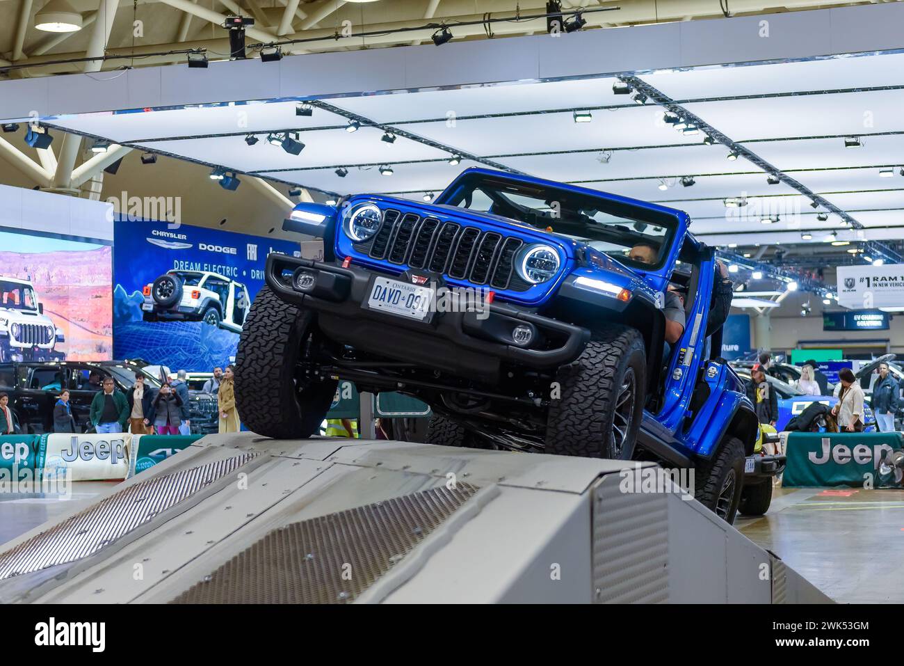 A blue Jeep Wrangler vehicle driving in a closed course with obstacles ...