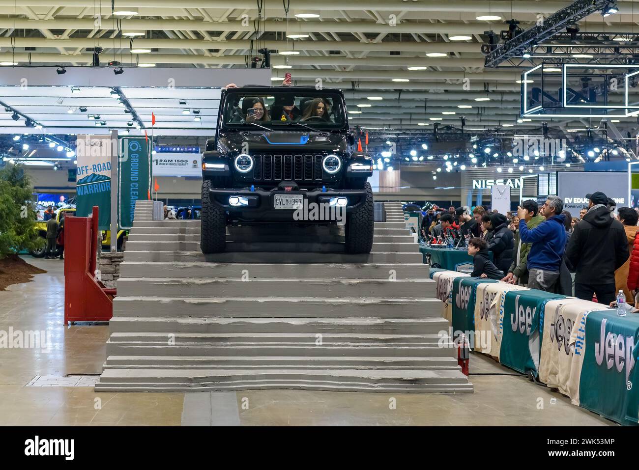A dark green Jeep Wrangler vehicle driving in a closed course with ...
