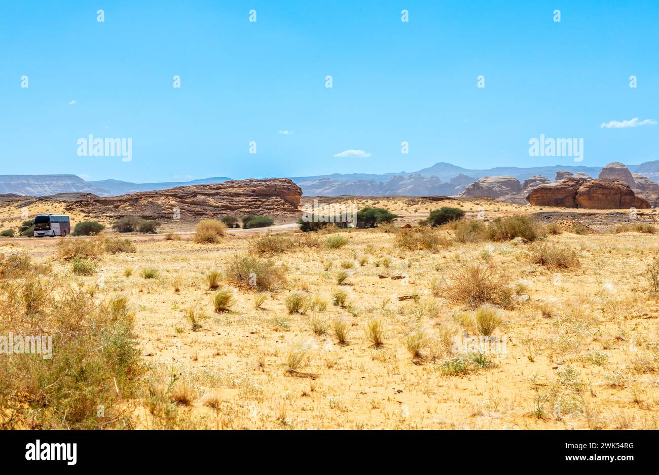 Desert sand landscape with mountains in the background and road with ...