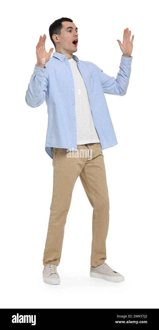 Shocked man in light blue shirt and beige pants on white background ...
