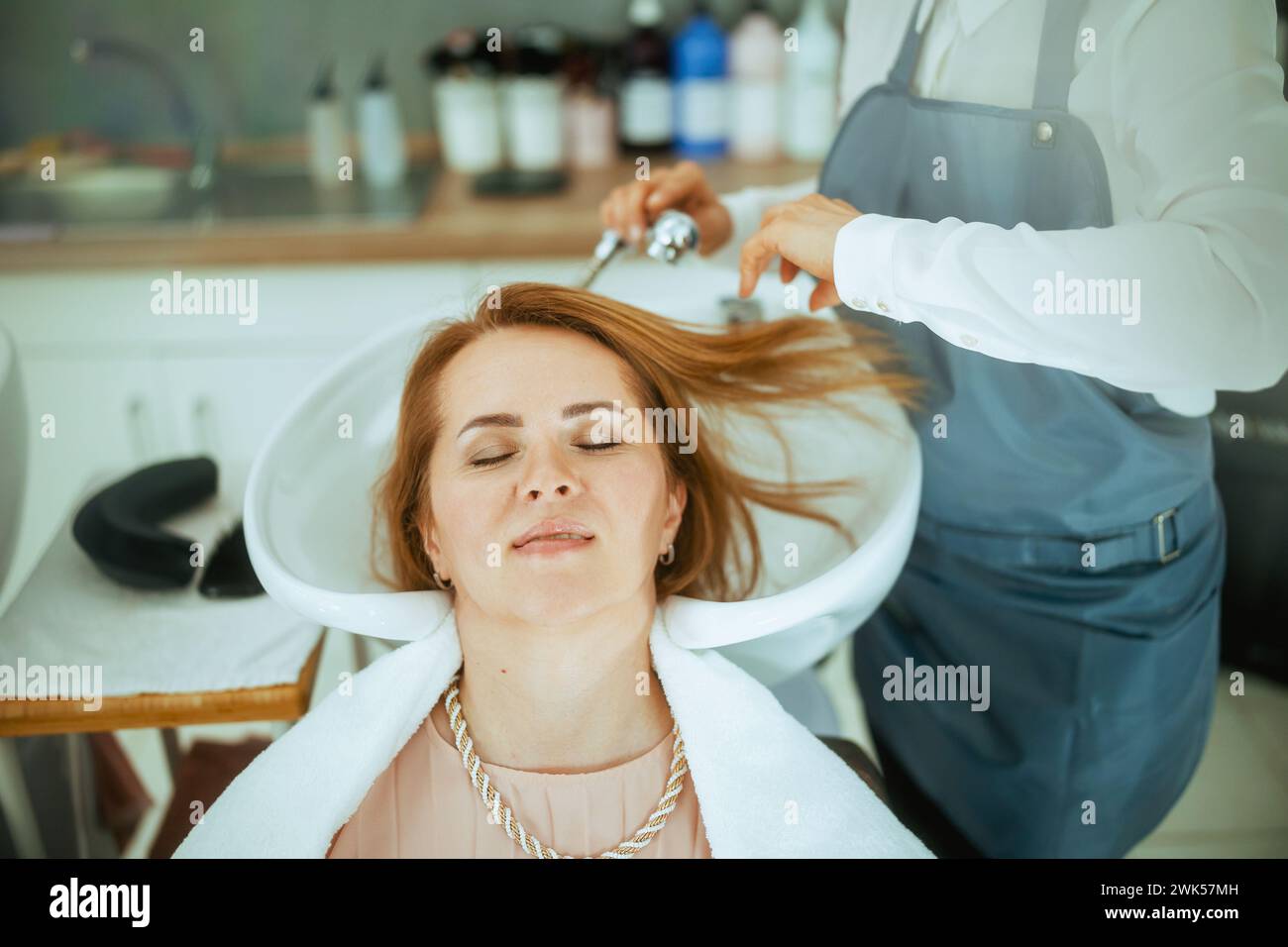 40 years old woman hairdresser in modern beauty studio with client ...
