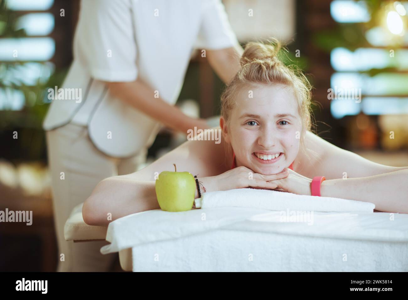 Healthcare time. female medical massage therapist in massage cabinet with teenage client and an ...