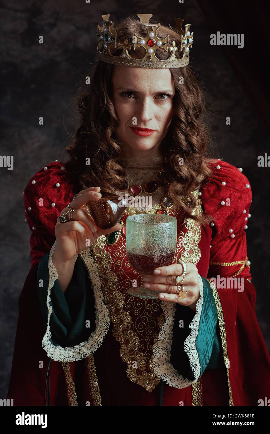 insidious medieval queen in red dress with crown pouring poison into ...