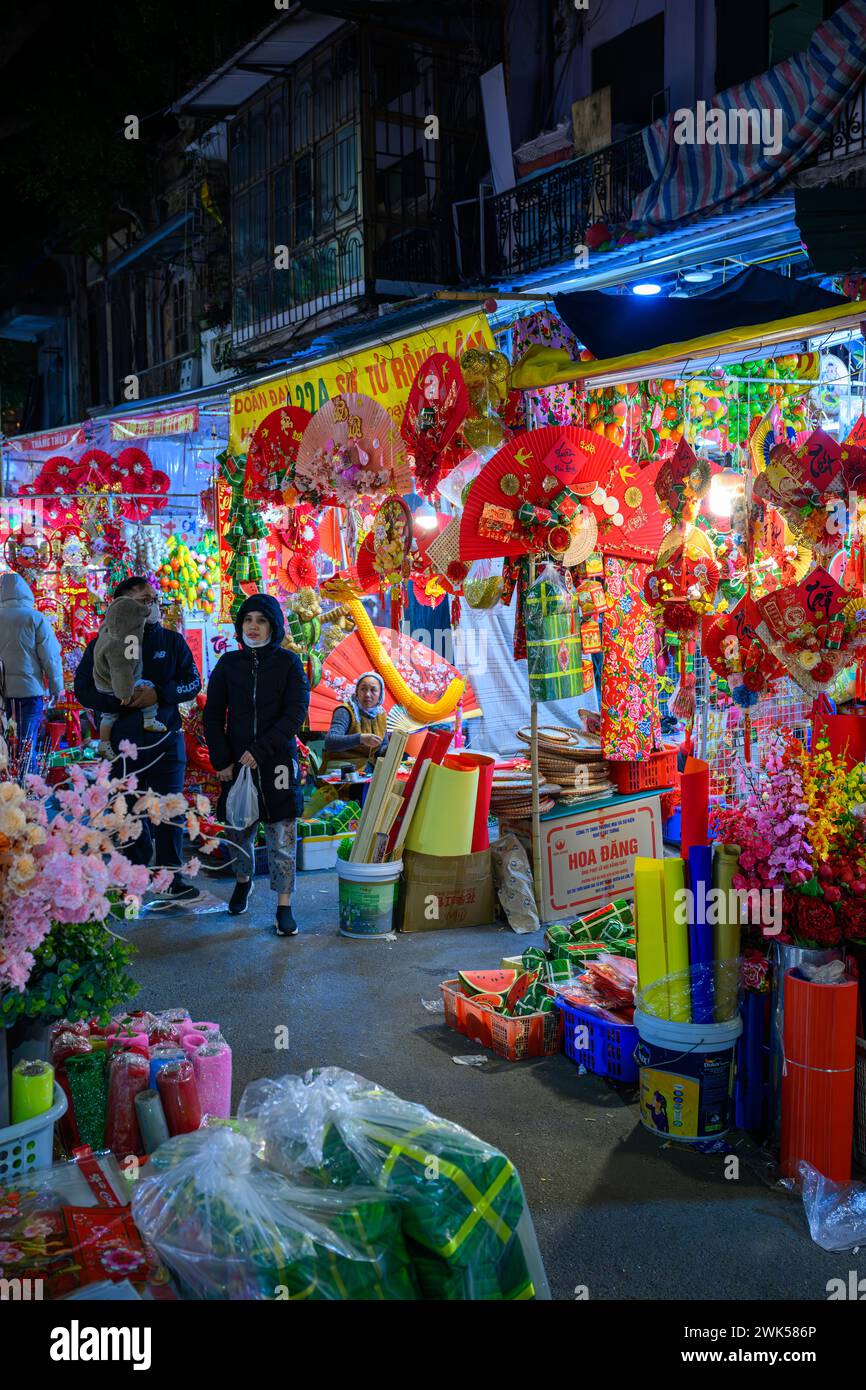 Buying brightly colored decorations for Tet Celebrations at the Hanoi ...
