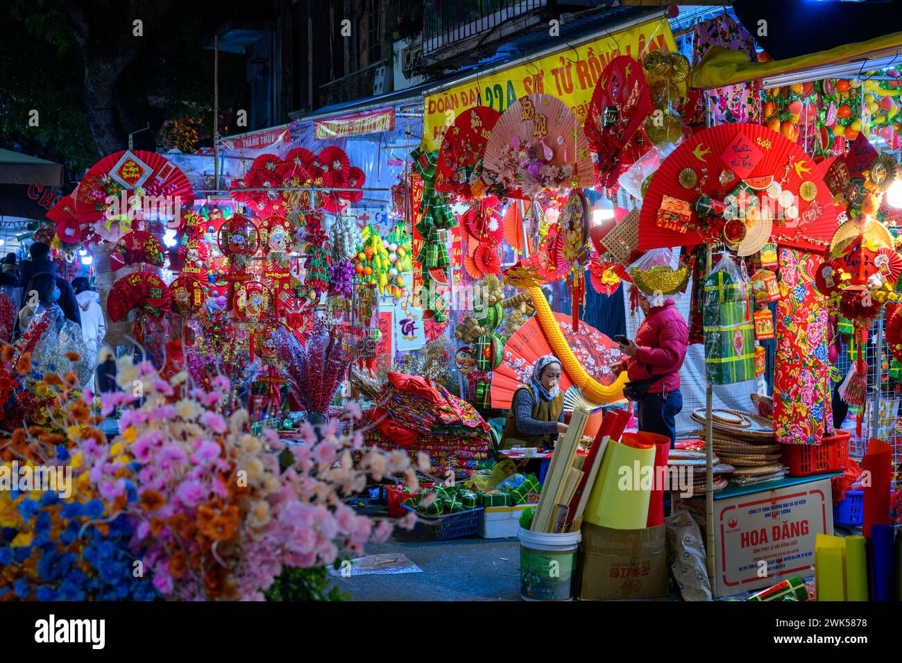 Buying brightly colored decorations for Tet Celebrations at the Hanoi ...