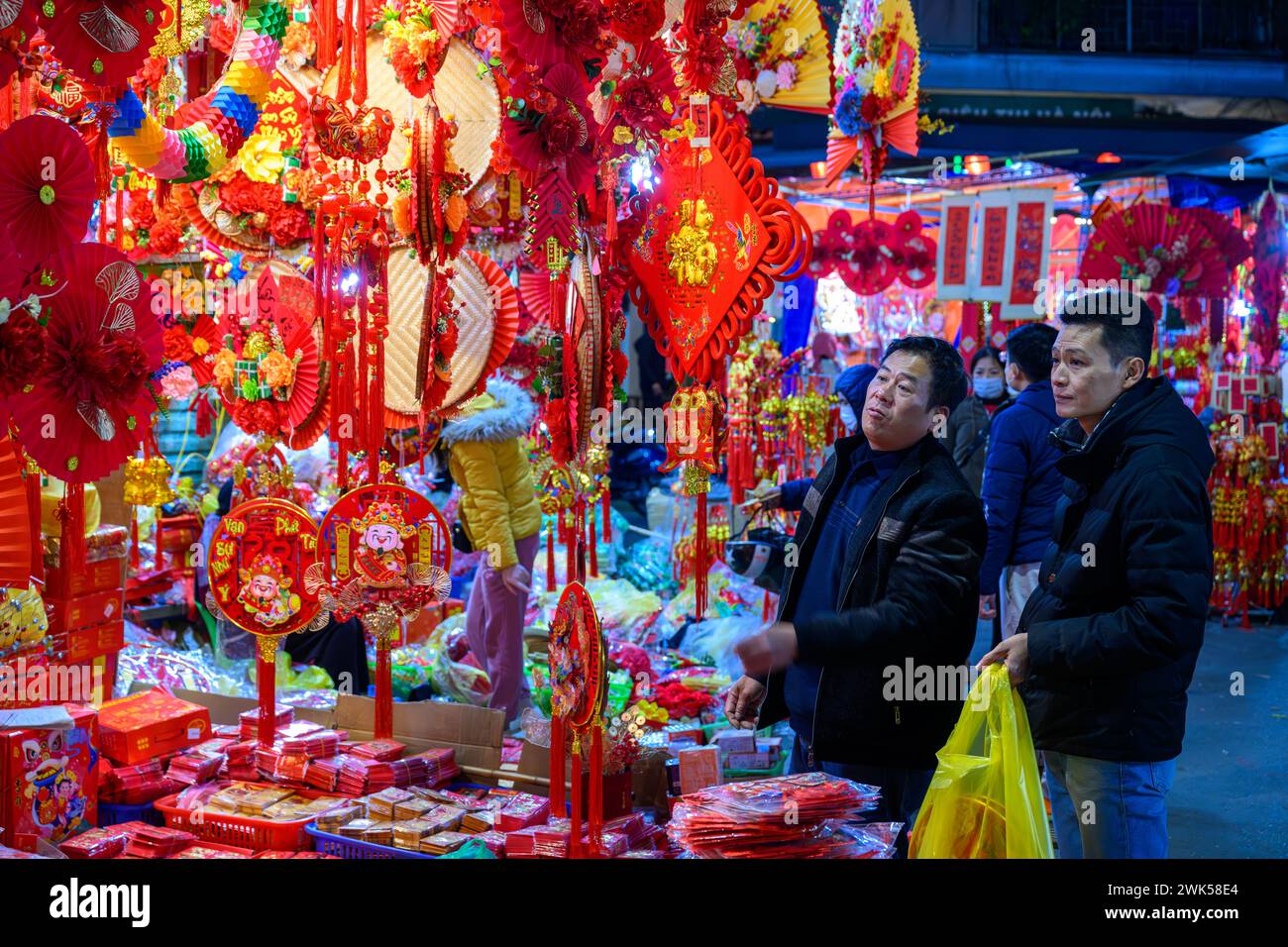 Buying brightly colored decorations for Tet Celebrations at the Hanoi ...