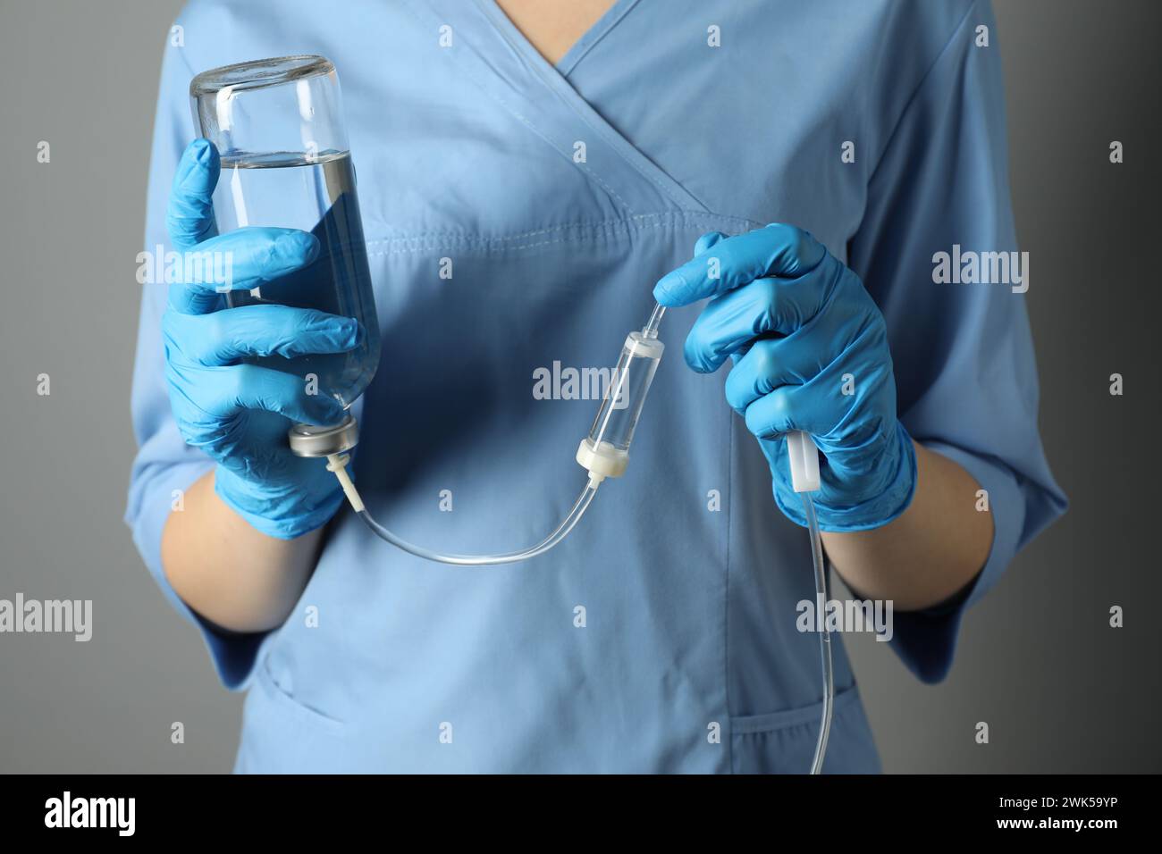 Nurse with IV infusion set on grey background, closeup Stock Photo - Alamy