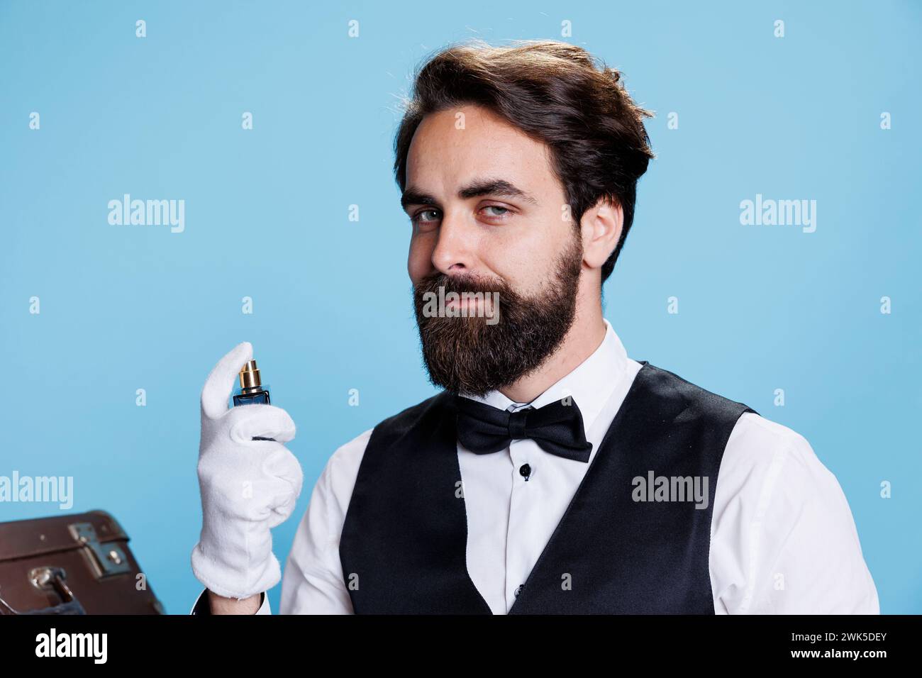 Rich elegant man spraying perfume, posing with bottle of luxurious ...