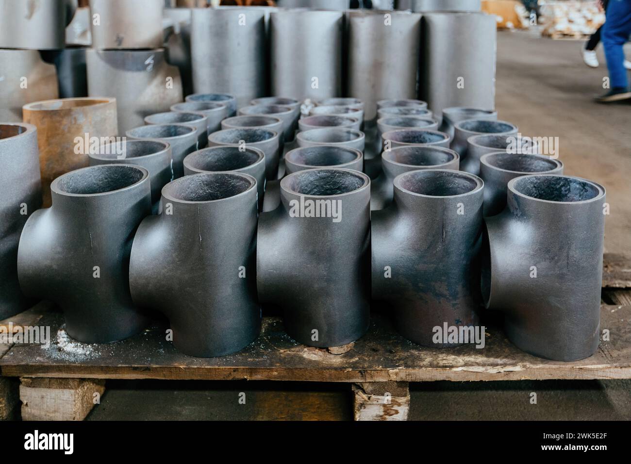 Batch of T shape pipe parts in factory Stock Photo - Alamy