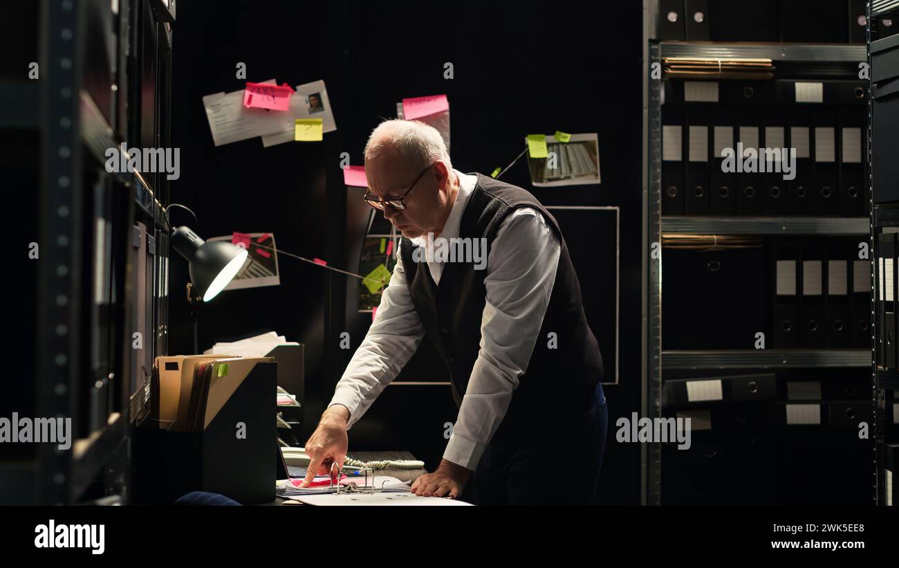 Police officer examining information on files classified records ...