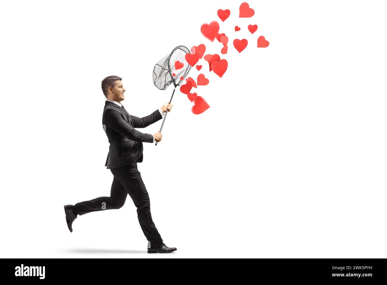 Man in a black suit running and catching hearts with a net isolated on ...